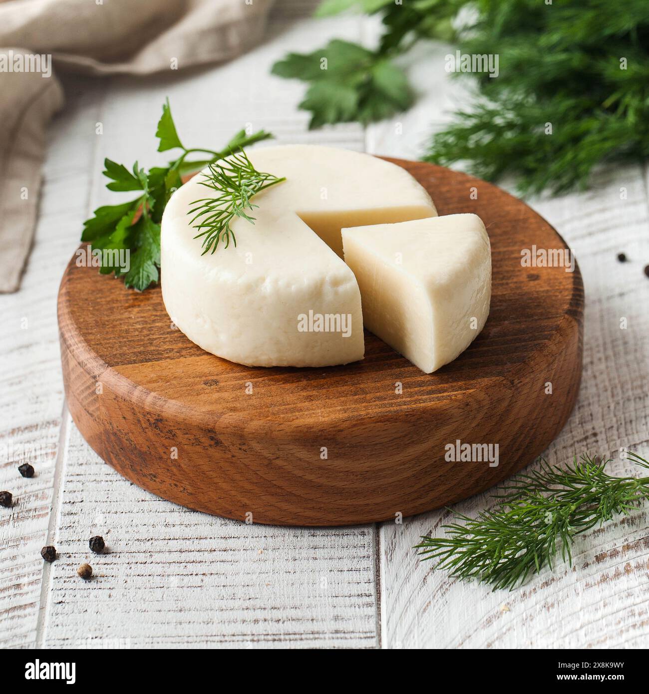 Traditional Georgian Sulguni cheese displayed on a wooden cutting board ...