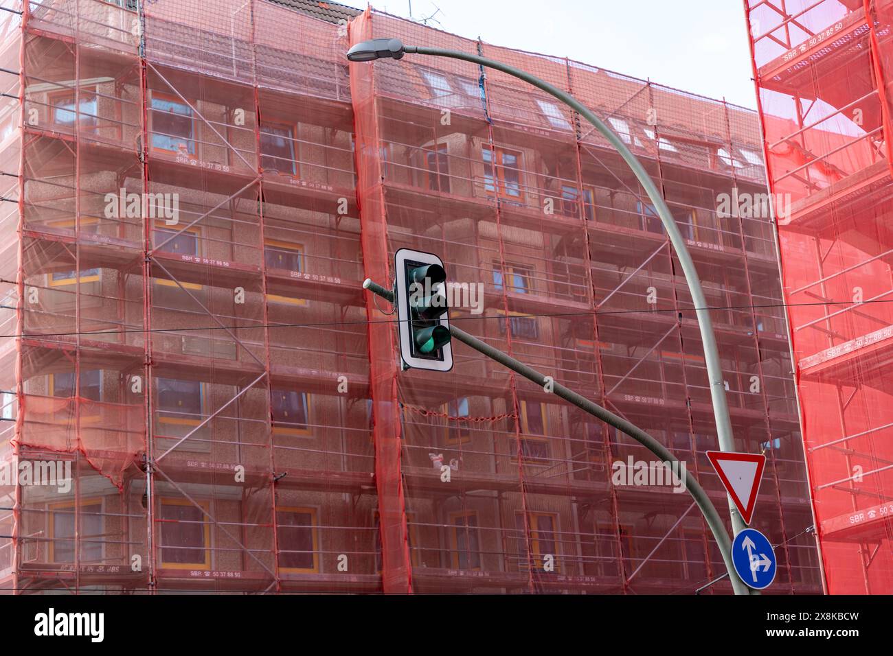 A traffic light is lit green in front of a building that is being ...