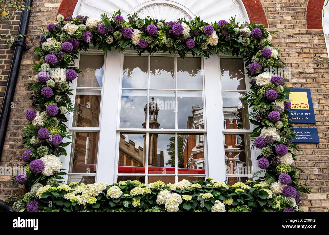 Elegant floral arch decoration around a window outside a brick building ...