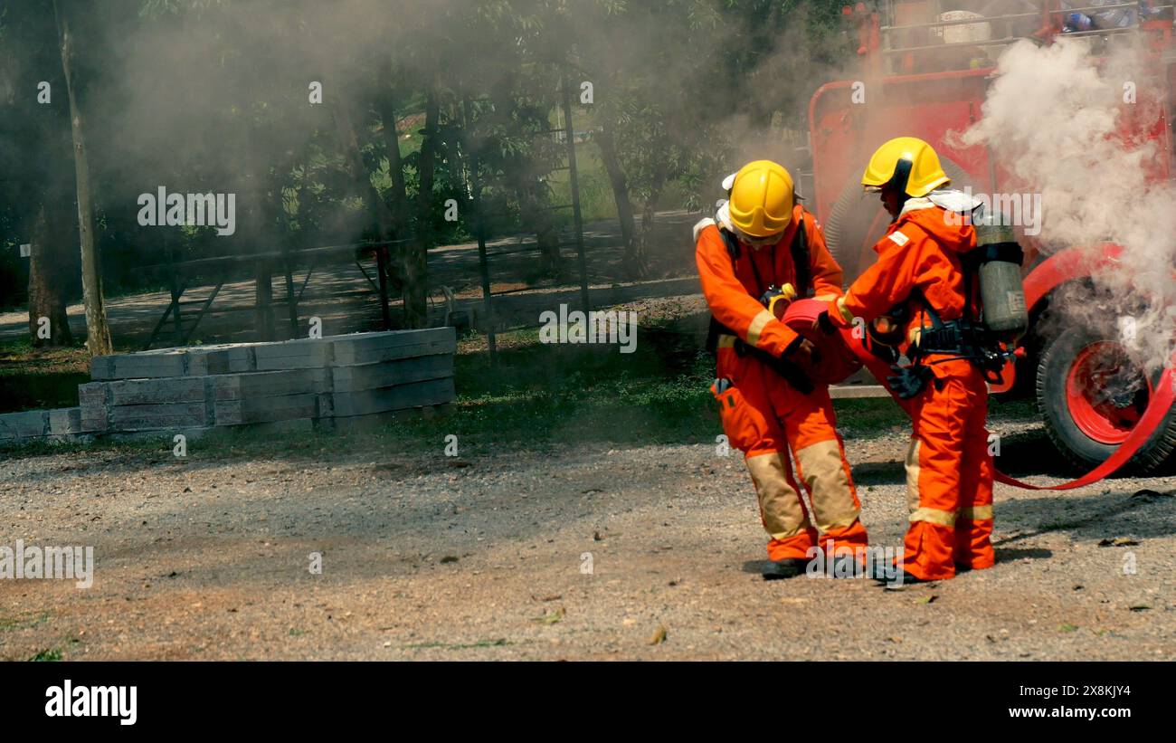 Firefighter fighting with flame using fire hose chemical water foam ...