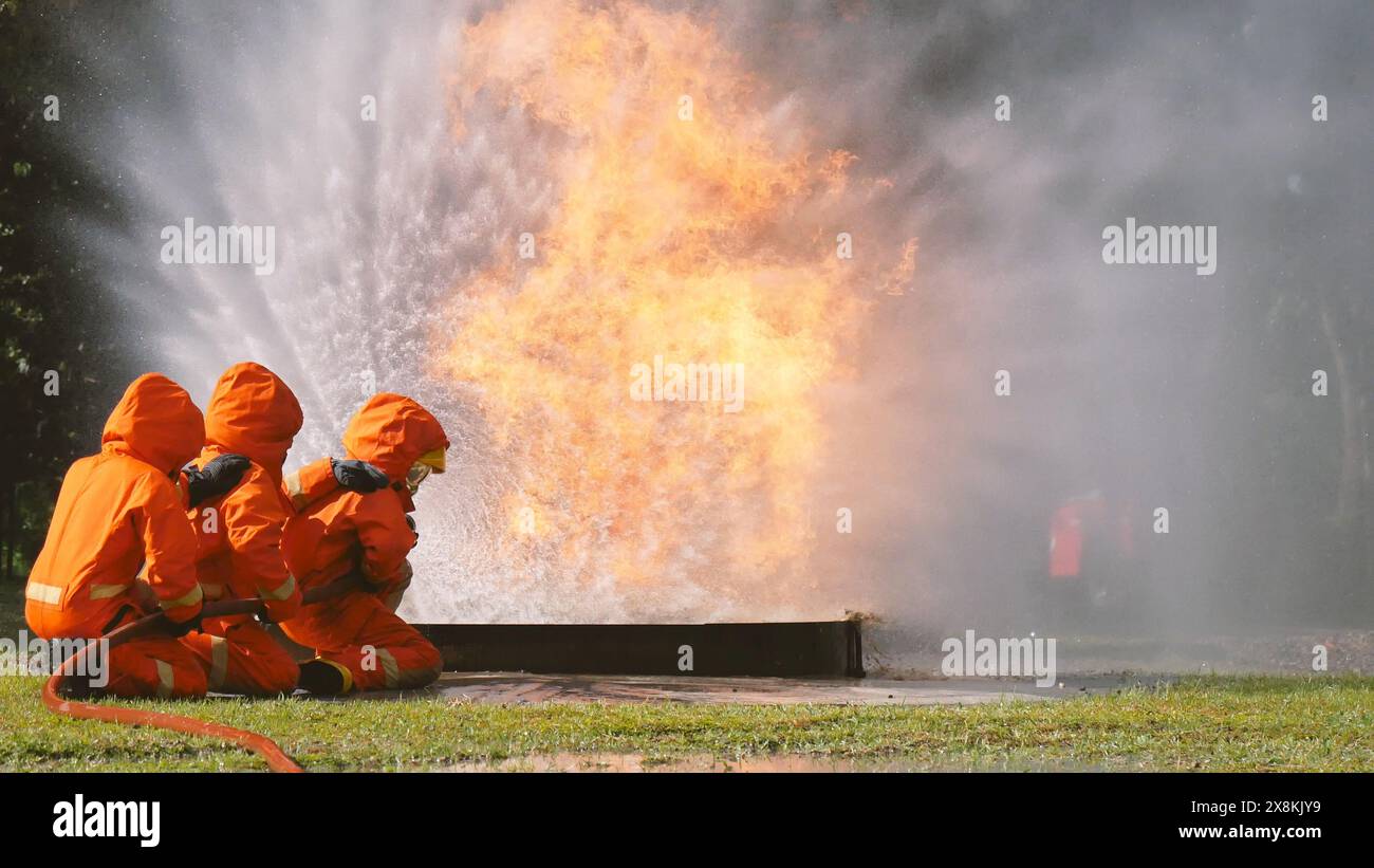 Firefighter fighting with flame using fire hose chemical water foam ...