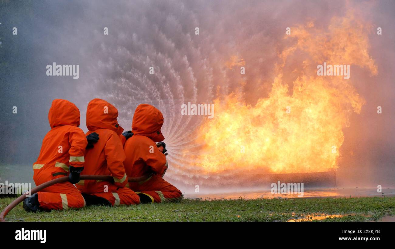 Firefighter fighting with flame using fire hose chemical water foam ...
