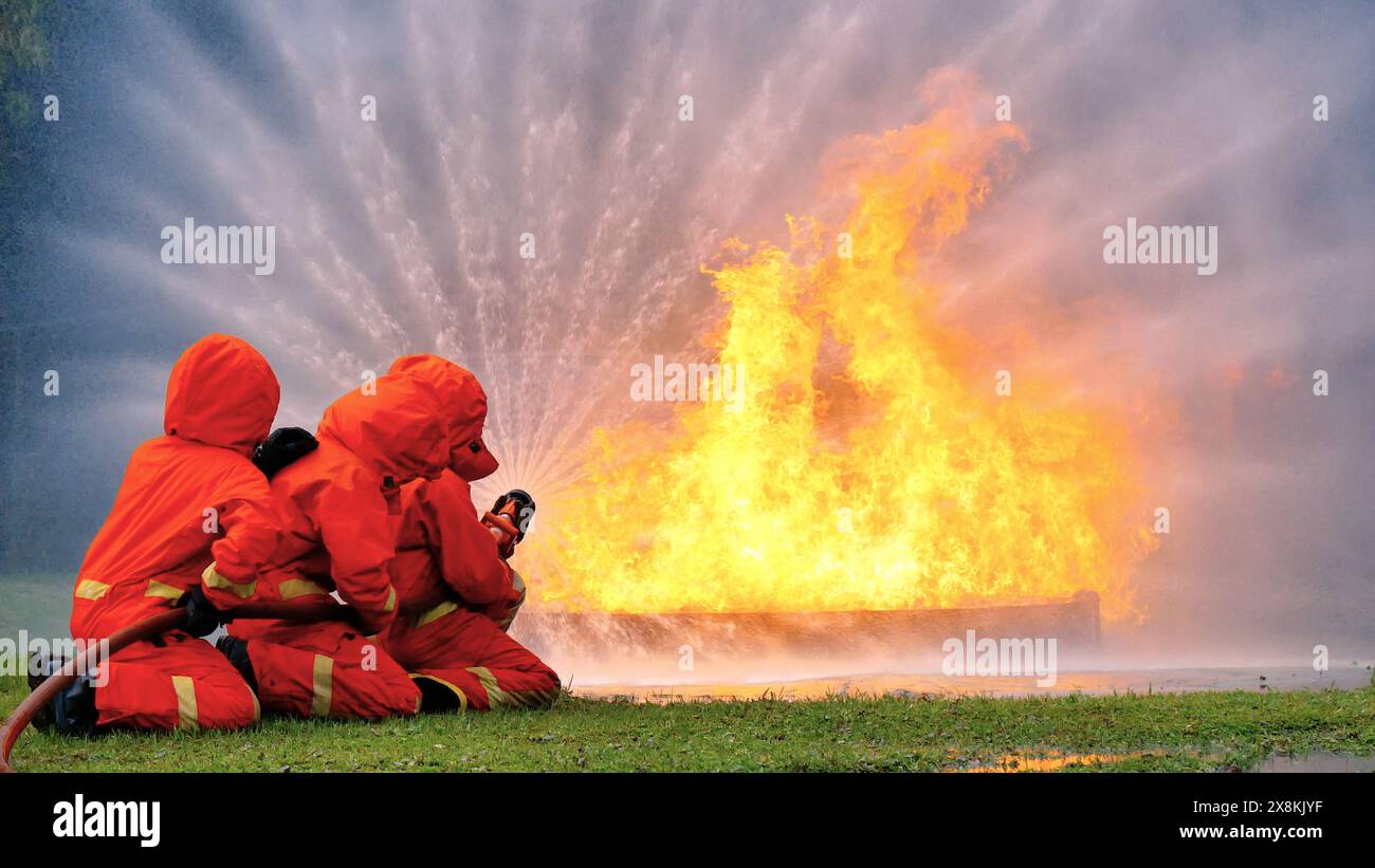 Firefighter fighting with flame using fire hose chemical water foam ...