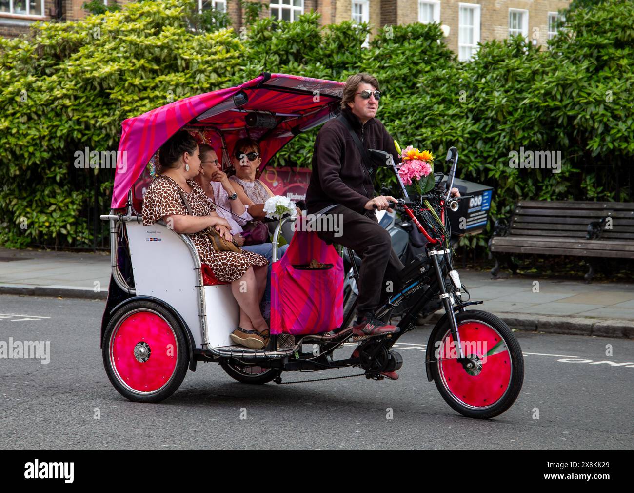 Pedal-powered rickshaw with driver and passengers on Kings road Chelsea ...