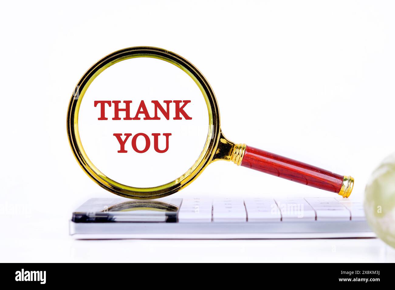 Thank you message written through the lens of a magnifying glass on a ...