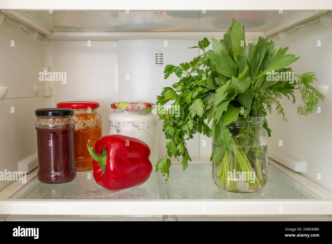 Parsley, lovage and dill leaves in a jar with water, inside a ...
