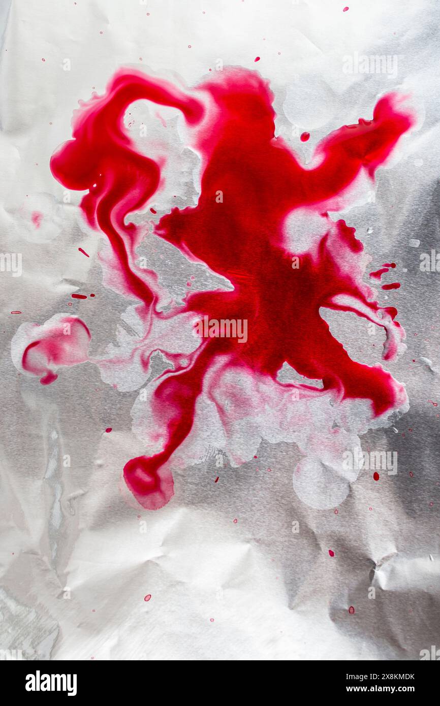 Red blood splatter on silver steel surface, soft focus close up ...