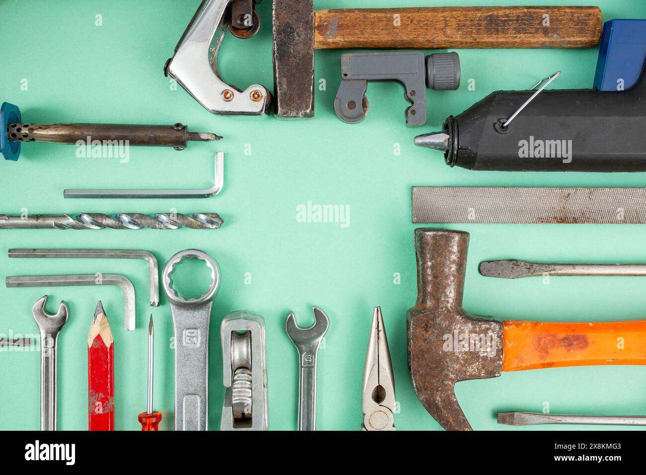Multiple hand tools arranged on green background, with empty square ...