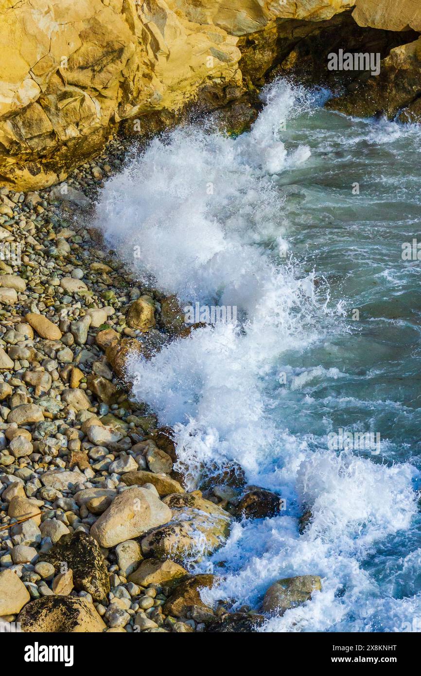A stunning blue coastline, with rapid waves crashing against rocky ...