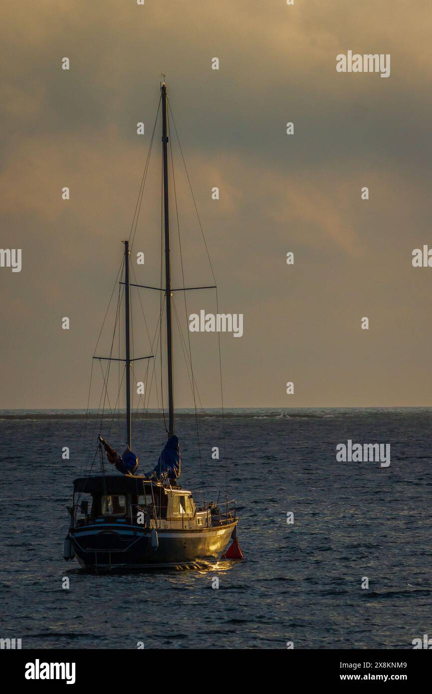 A majestic blue sailboat cuts through the horizon over a vast and ...