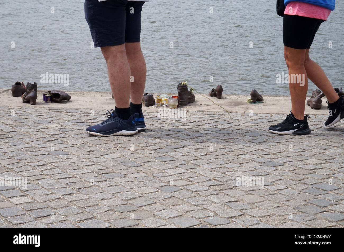 Tourists passing the Shoes on the Danube Bank commenorating the Jews ...
