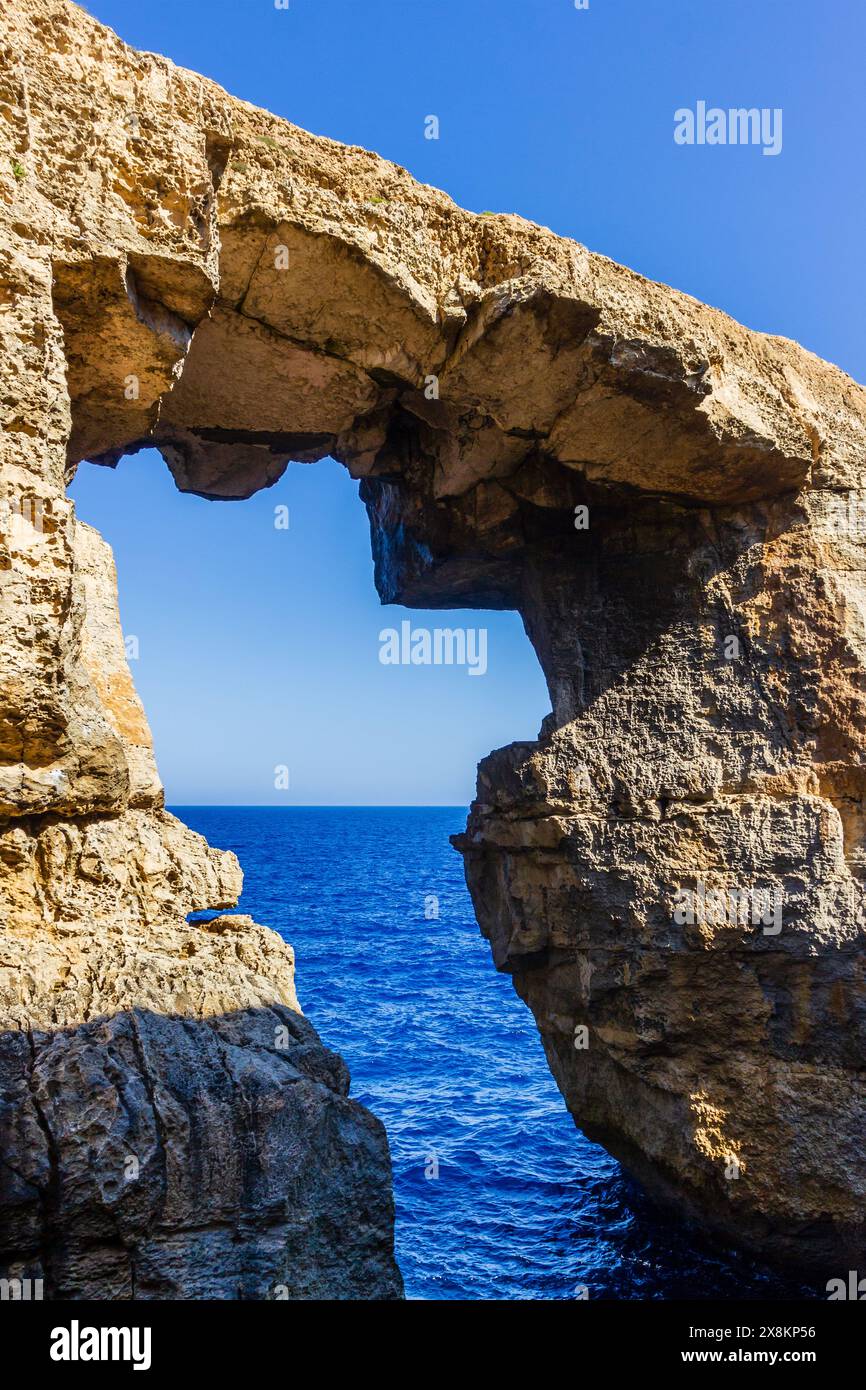 Majestic ancient rock arch on coastal cliff, clear blue sky, serene ...