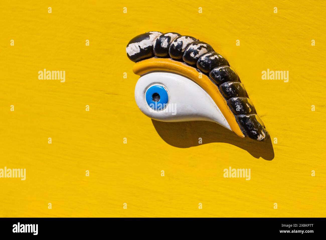 Captivating eye on yellow background symbolizes good luck Stock Photo ...