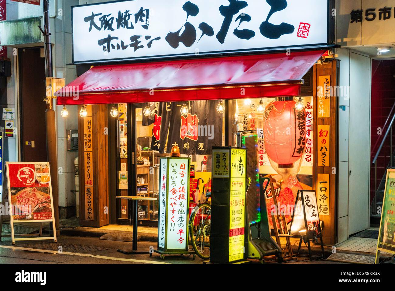 Front and entrance of brightly illuminated Japanese yakiniku (frilled ...