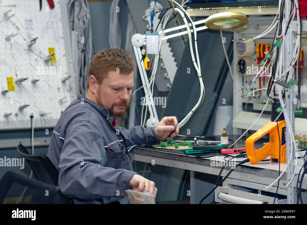 Perm, Russia - May 23, 2024: worker assembling electrical equipment in ...