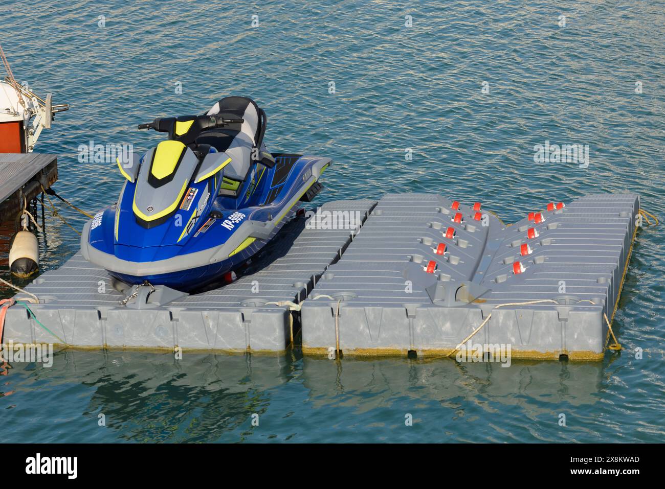 A blue and gray Yamaha jet ski is sitting on a raft in the water, San ...
