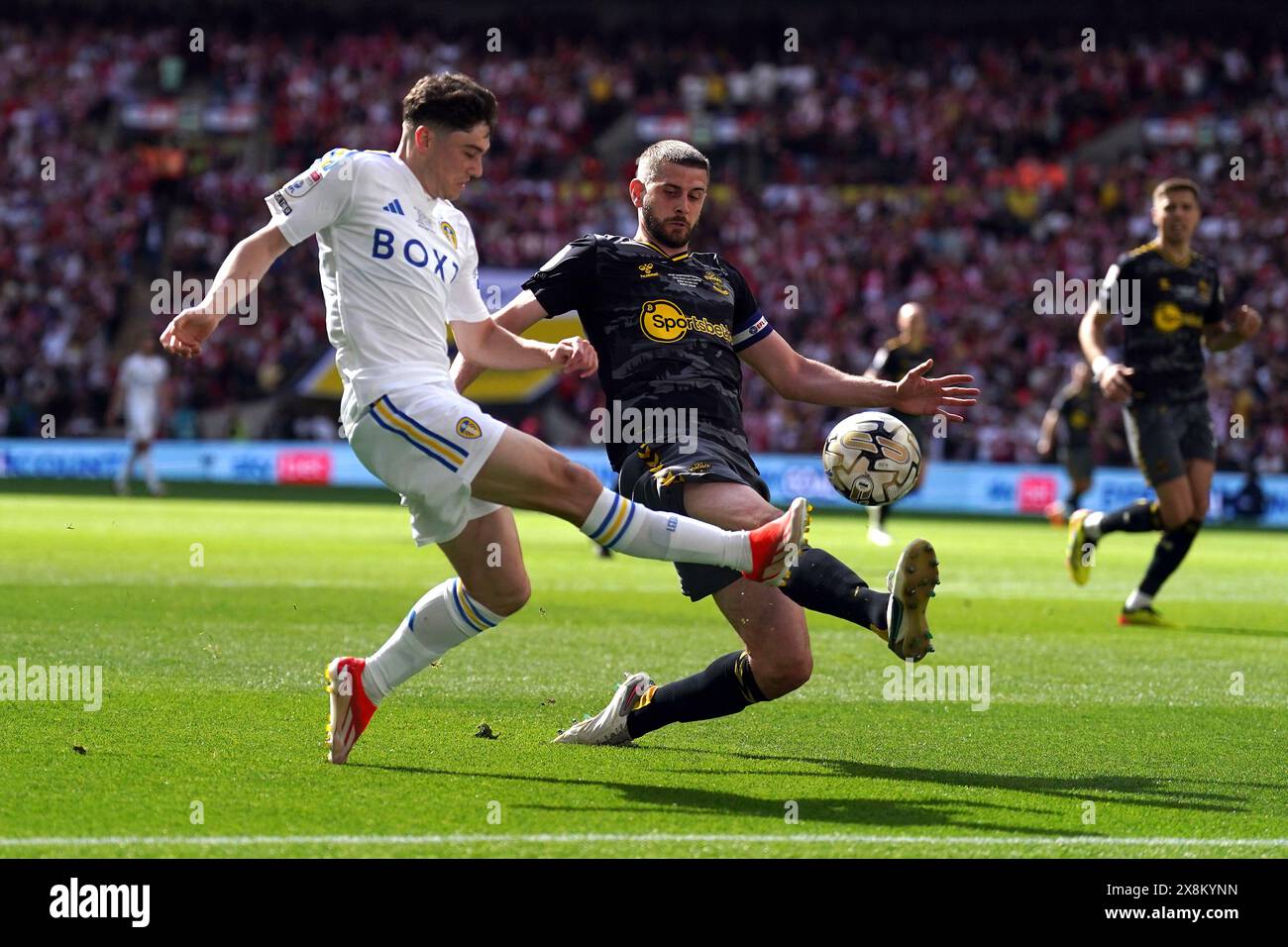 Leeds United's Daniel James (left) attempts to cross the play past ...