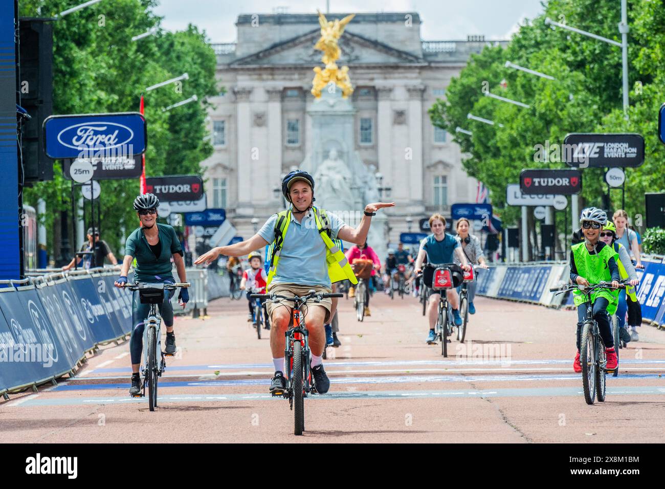 London, UK. 26 May 2024. People of all ages celebrate crossing the finish line on the Mall, even ...