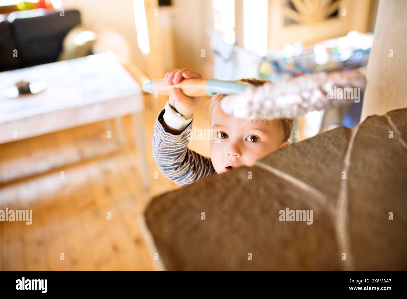 Little boy helping mother with hosehold chores, dusting cleaning their ...