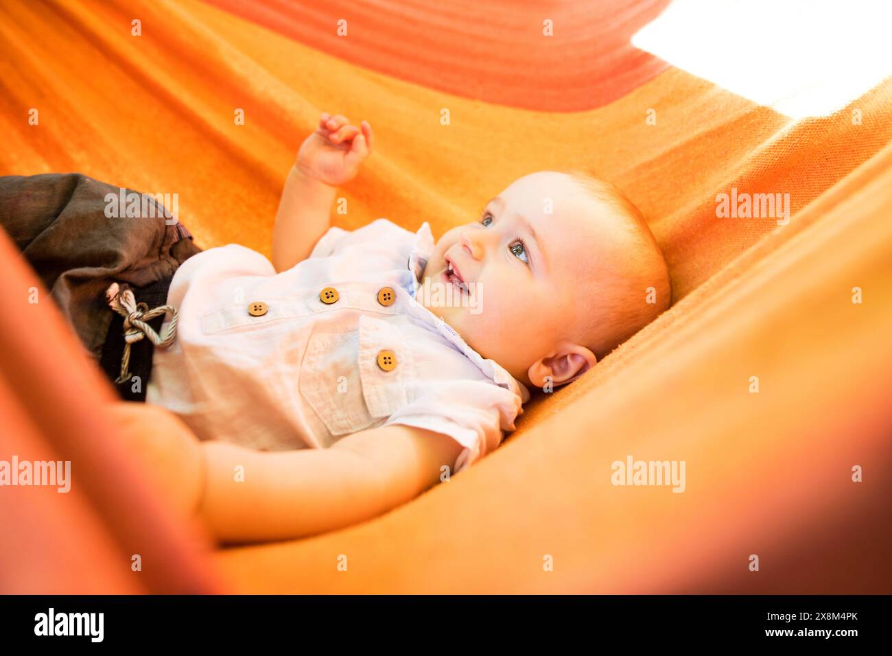 The baby is lying in a rocking hammock during a warm summer day Stock ...