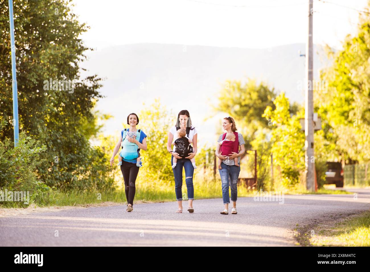 Mothers carrying babies in carriers, slings or wraps. Babywearing Stock ...