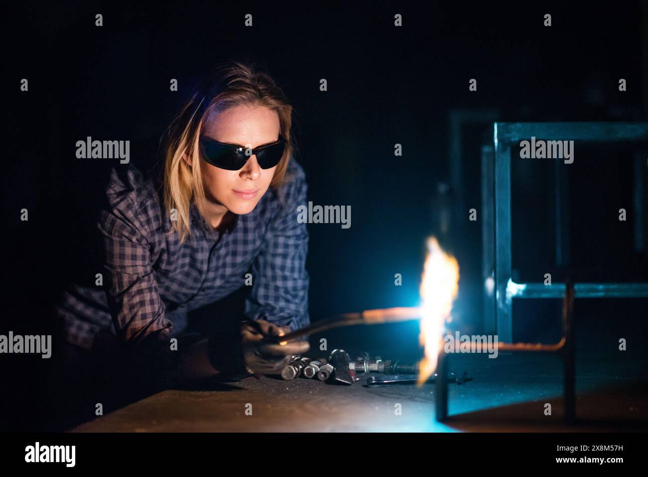 Beautiful blonde woman works as a welder in workshop, operating welding ...