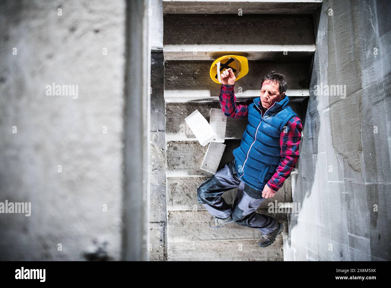 Male worker lying on the stairs after fall. Work injury, accident in ...