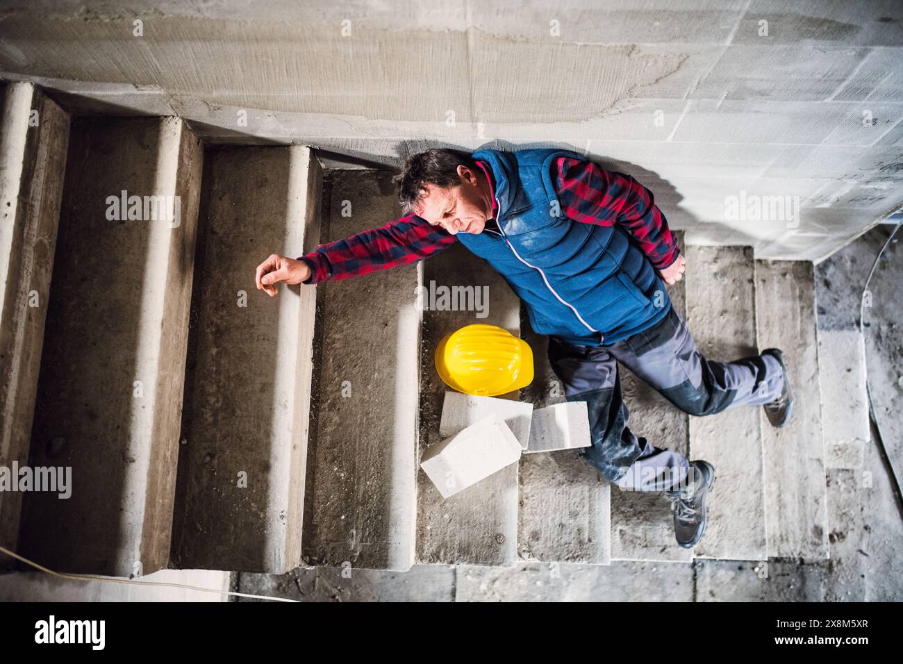 Male worker lying on the stairs after fall. Work injury, accident in ...