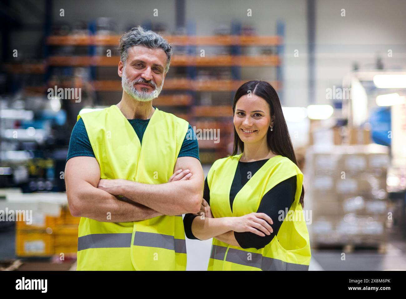 Warehouse employees in warehouse. Two workers in reflective clothing in ...