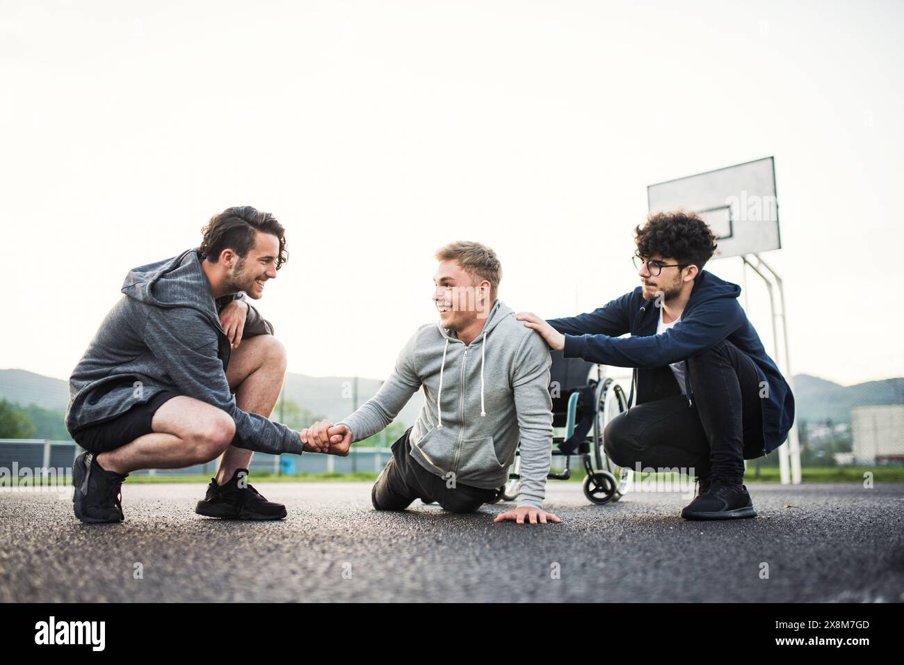 Disabled young man exercising with his supportive friends. Male ...