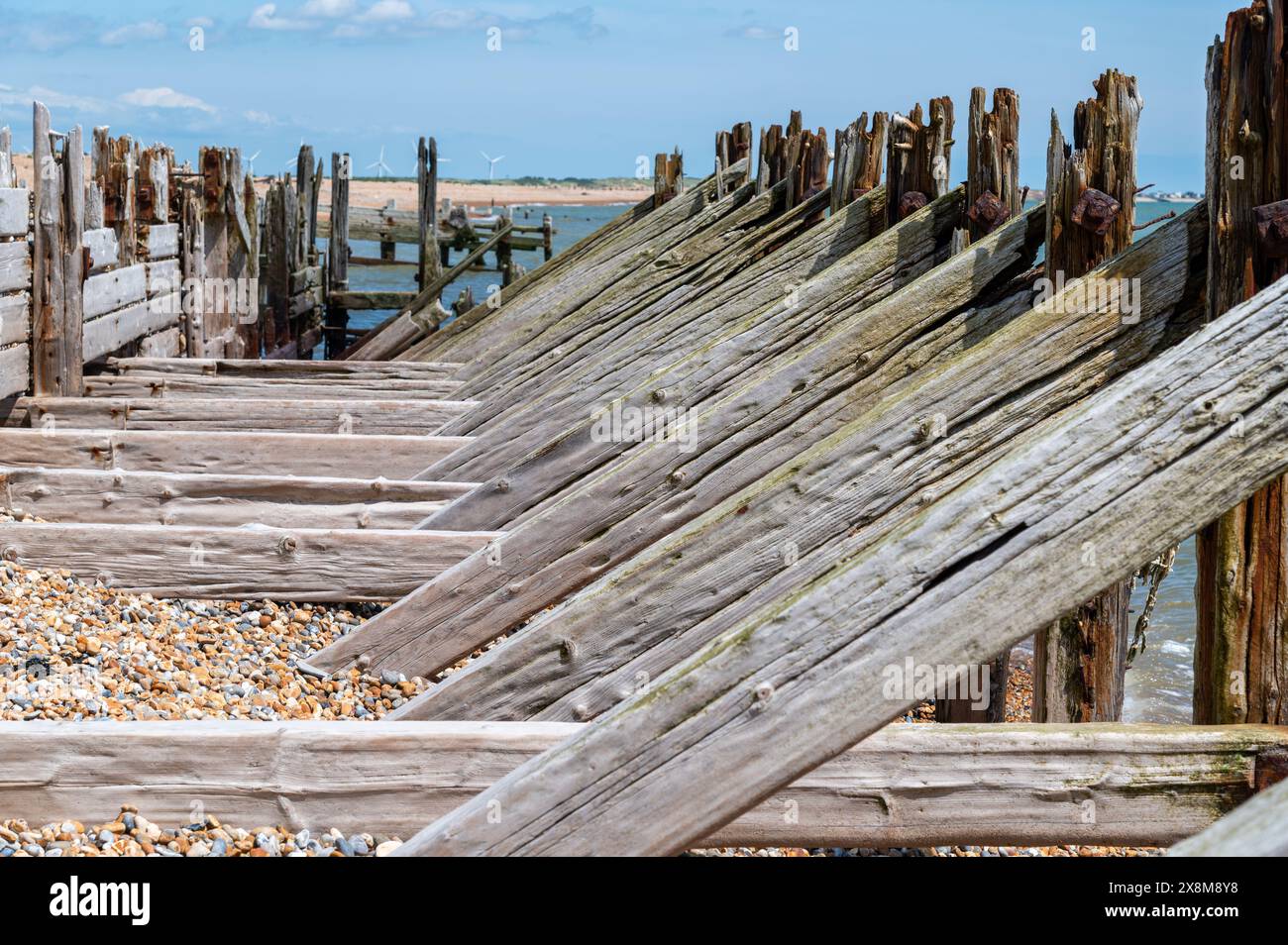 Old wooden sea defences and breakwaters at Rye Harbour with heavy ...
