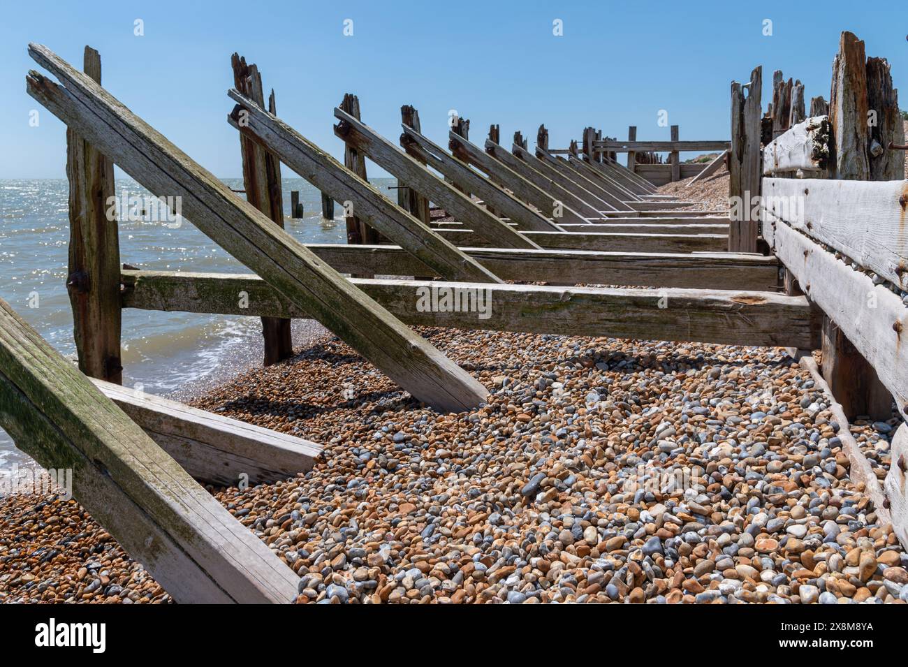 Old wooden sea defences and breakwaters at Rye Harbour with heavy ...
