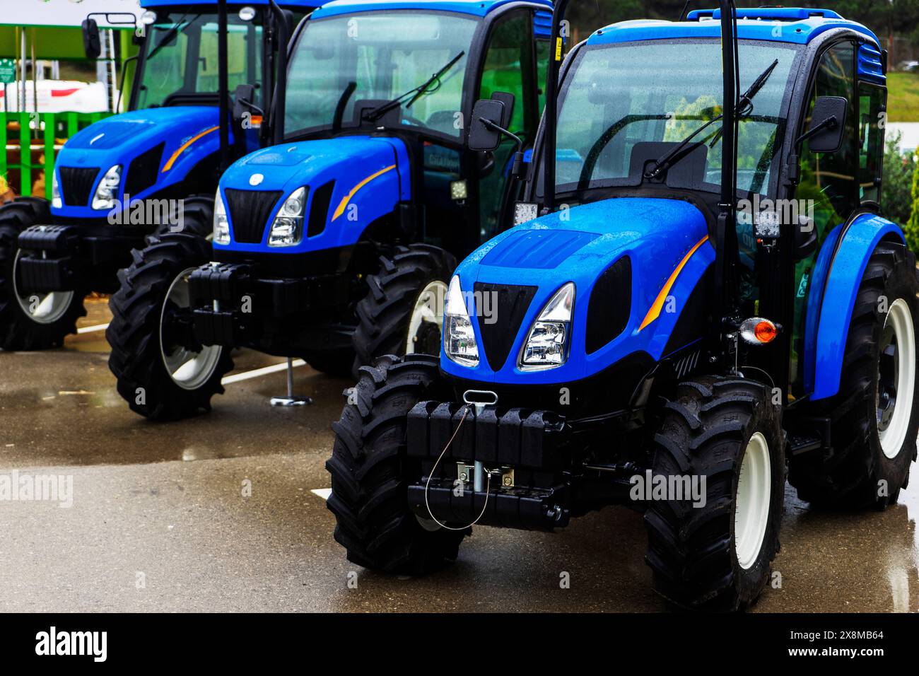 The new blue agricultural tractors of various models stand in a row at ...
