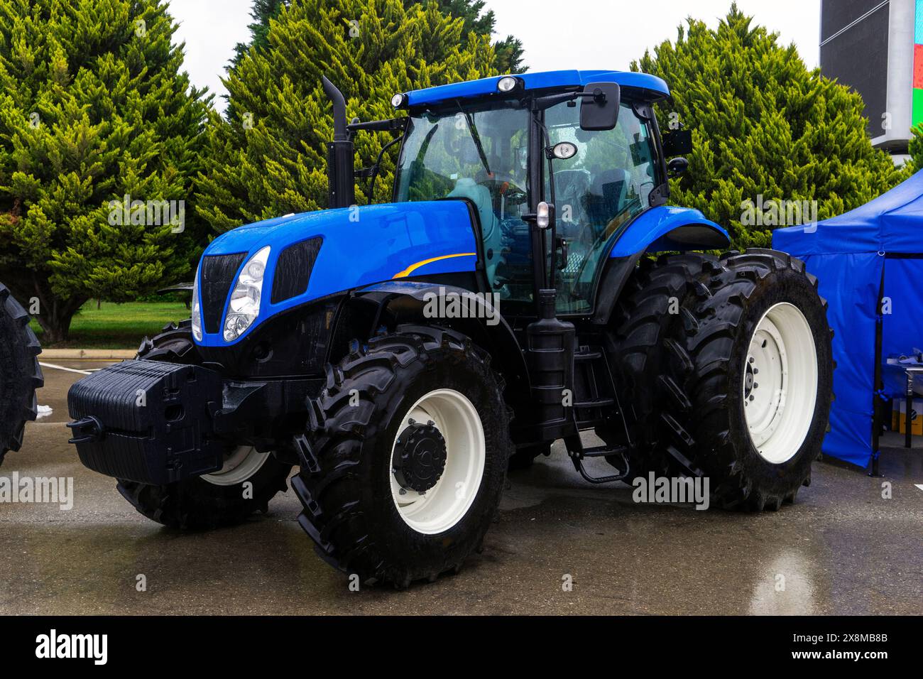 The new blue agricultural tractors of various models stand in a row at ...