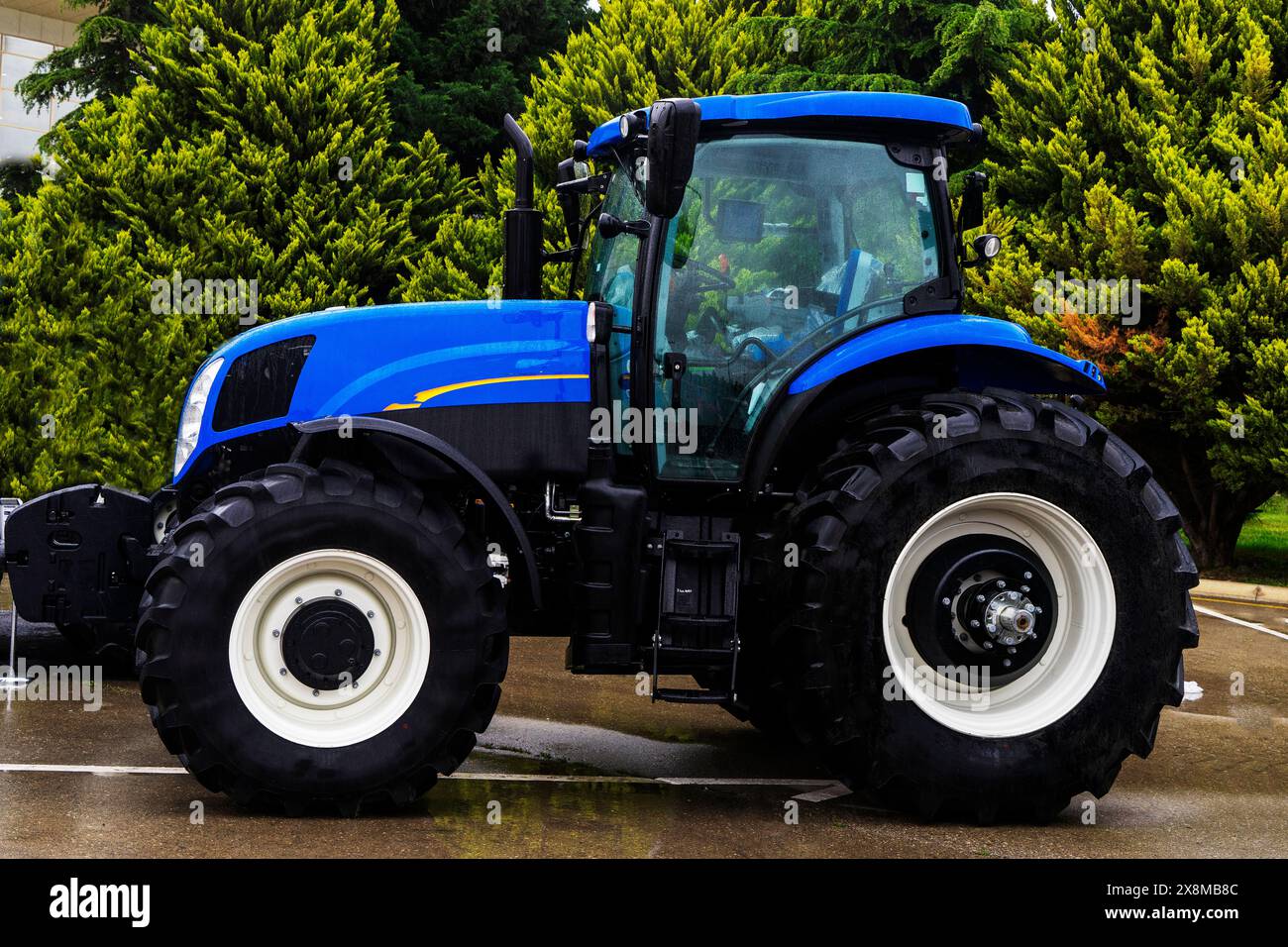 The new blue agricultural tractors of various models stand in a row at ...