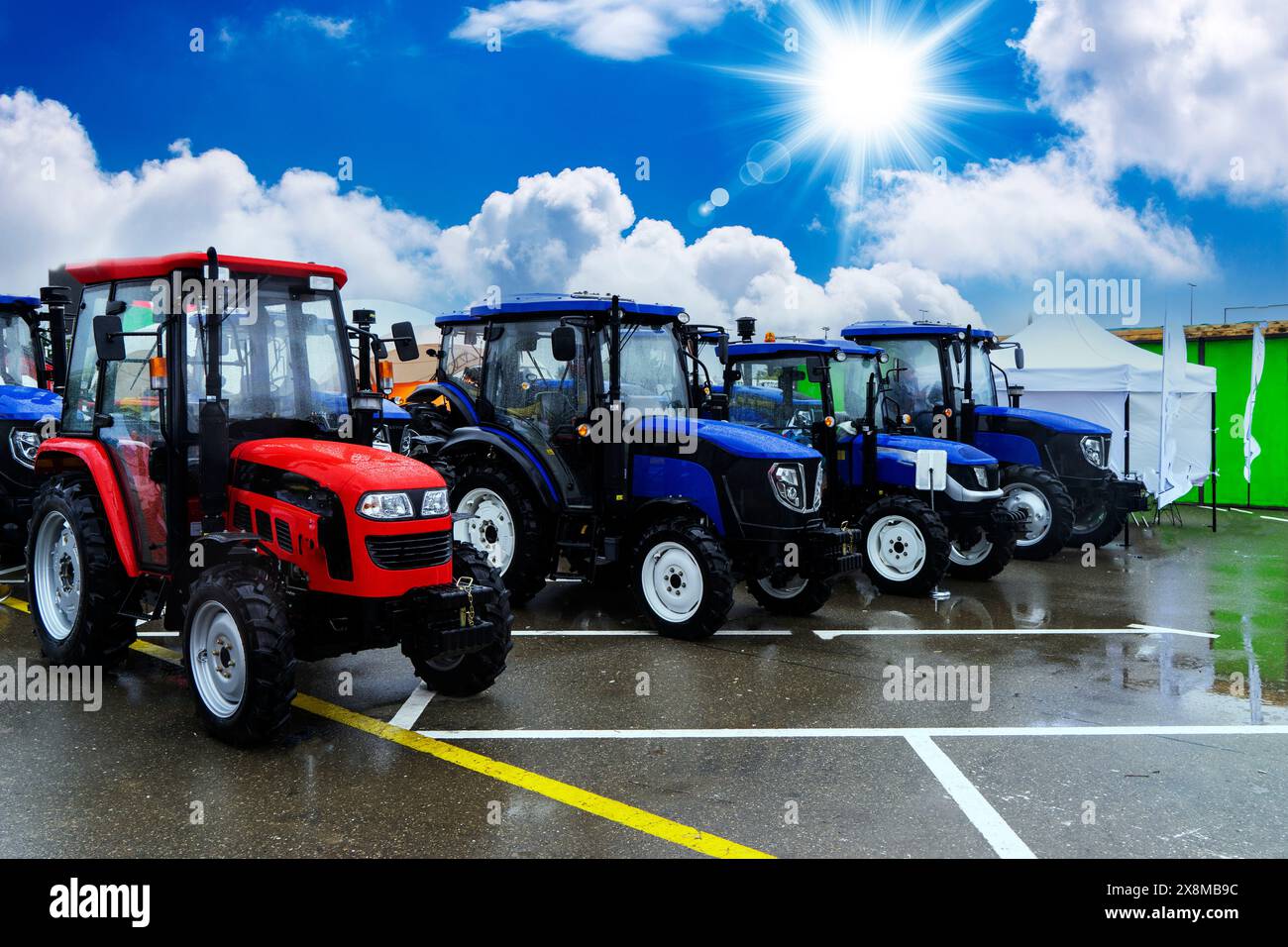 The new blue agricultural tractors of various models stand in a row at ...