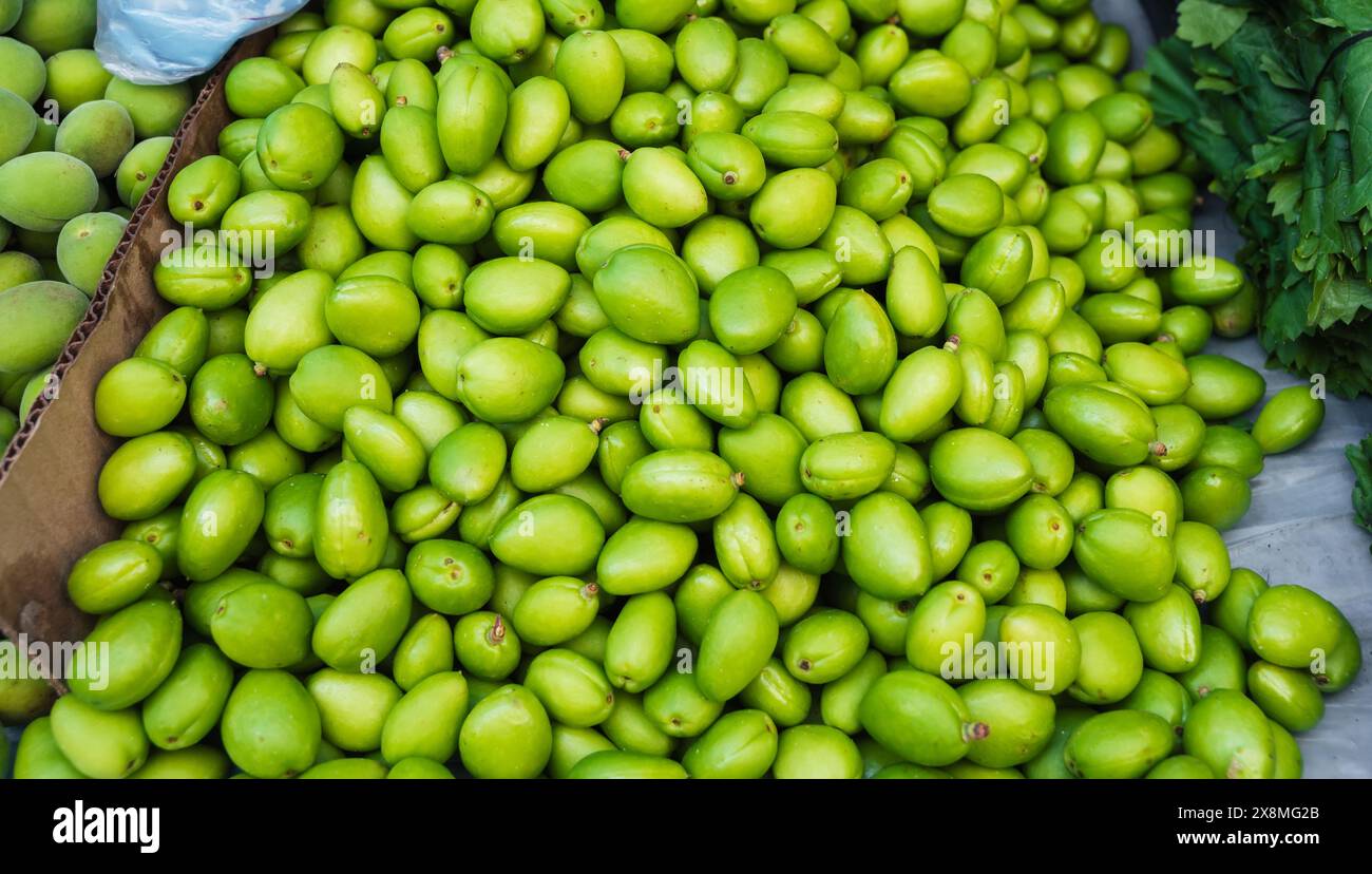 unripe green apricot on counter of a bazaar in Uzbekistan. Traditional ...
