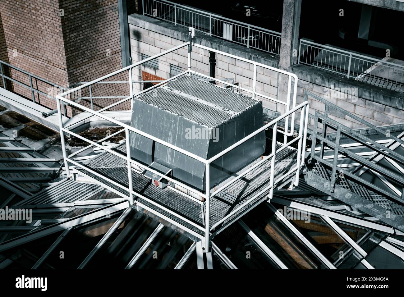 Industrial rooftop AC unit with metal safety railings, highlighting modern urban infrastructure ...