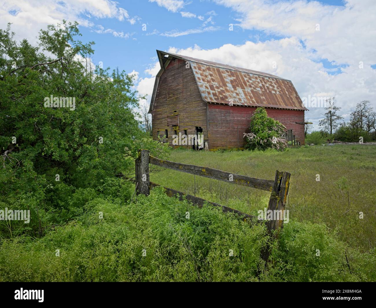 A landscape photo of an old abandoned barn under a dramatic cloudy sky ...