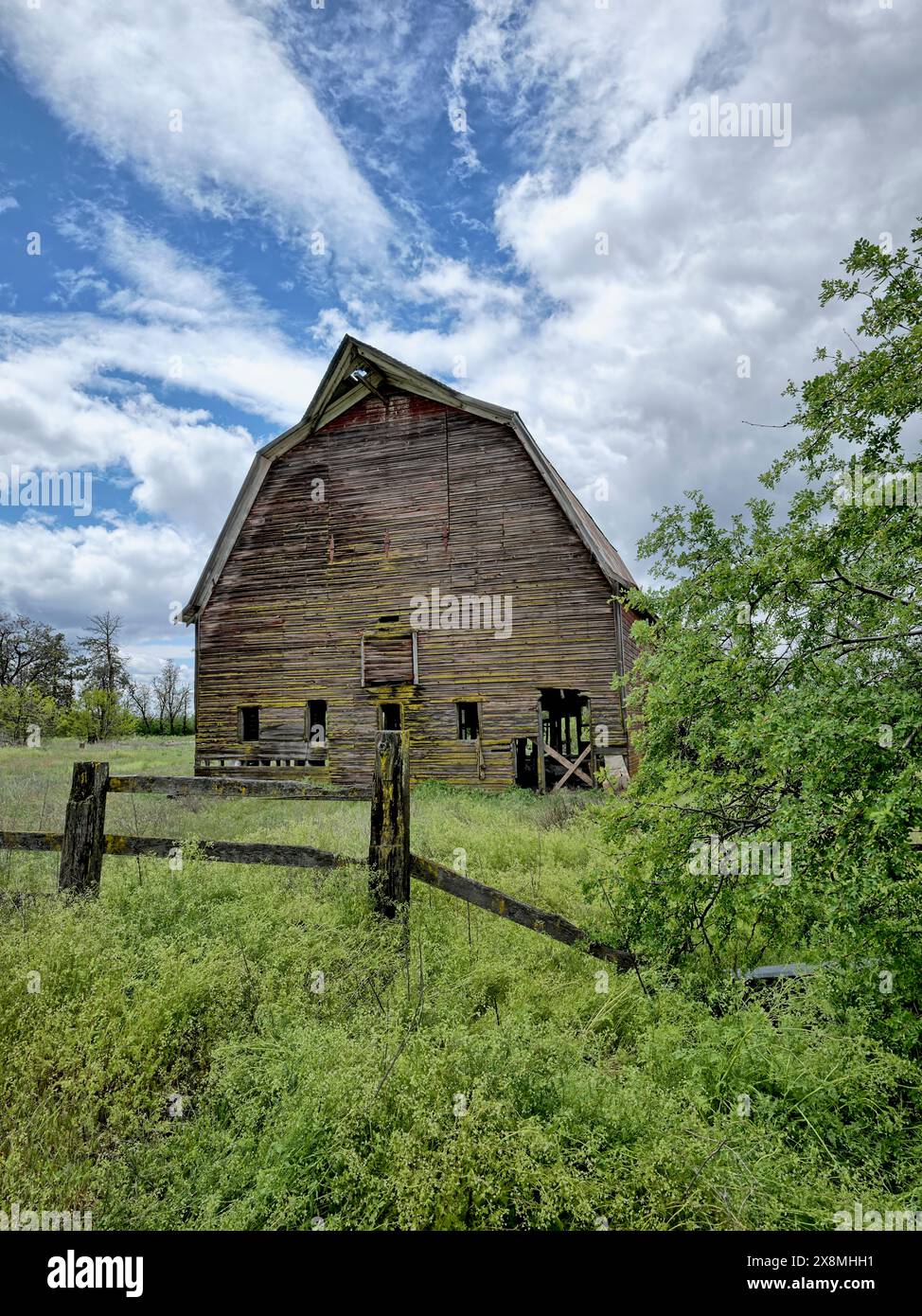 A landscape photo of an old abandoned barn under a dramatic cloudy sky ...