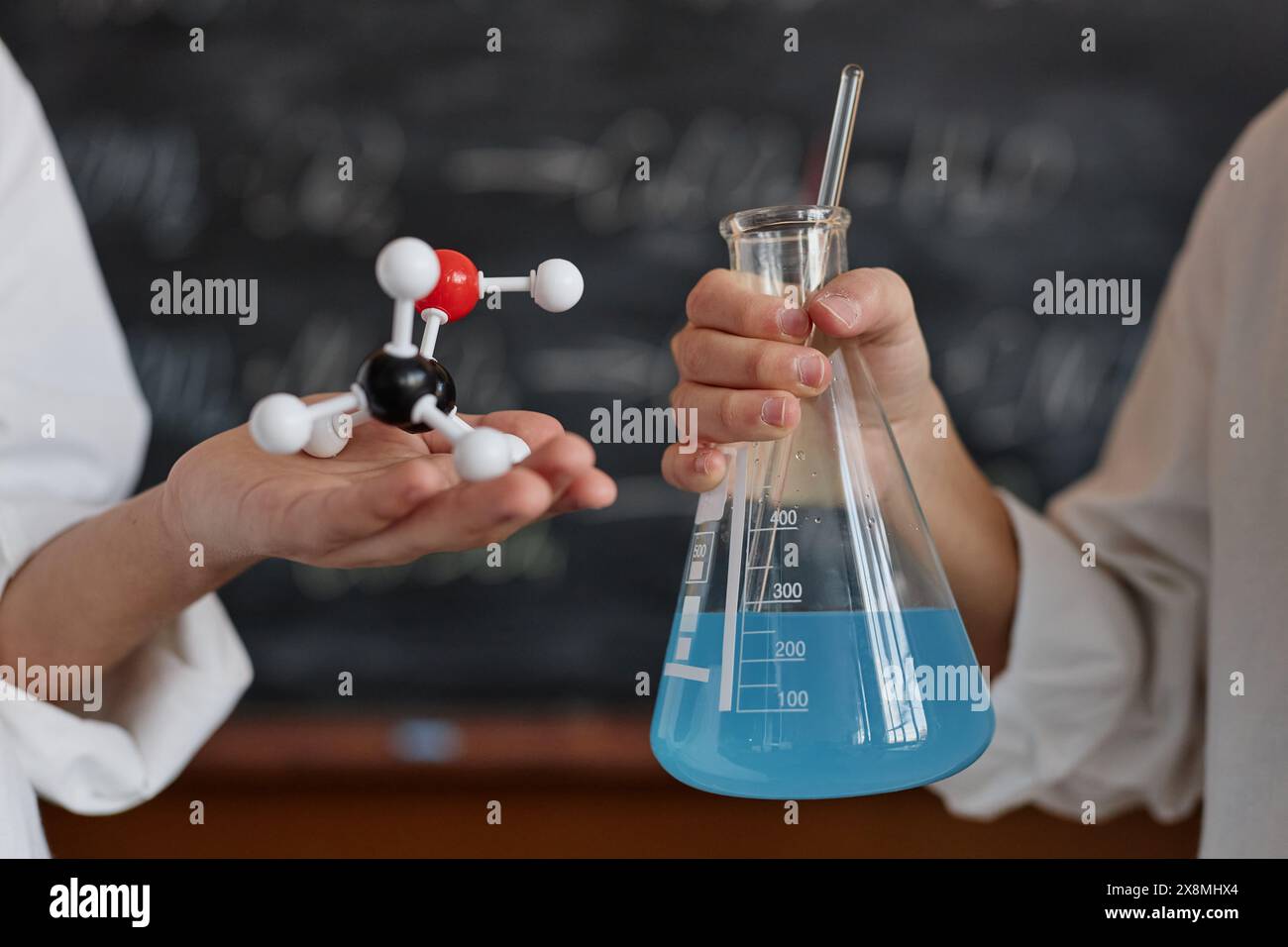 Closeup shot of hands of two unrecognizable students holding laboratory ...