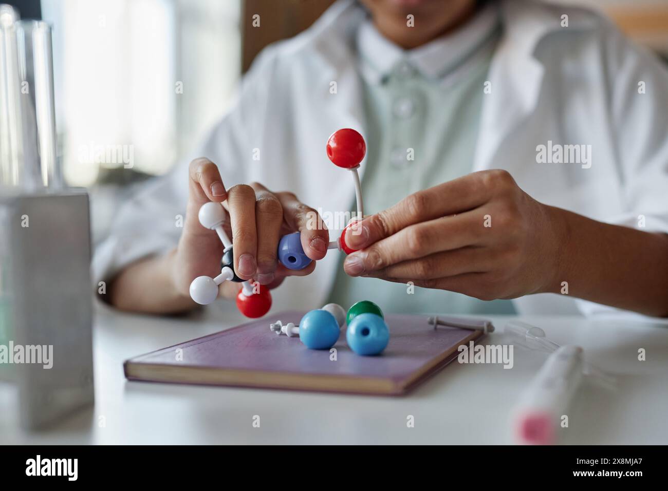 Closeup of hands of unrecognizable Black schoolboy wearing white lab ...