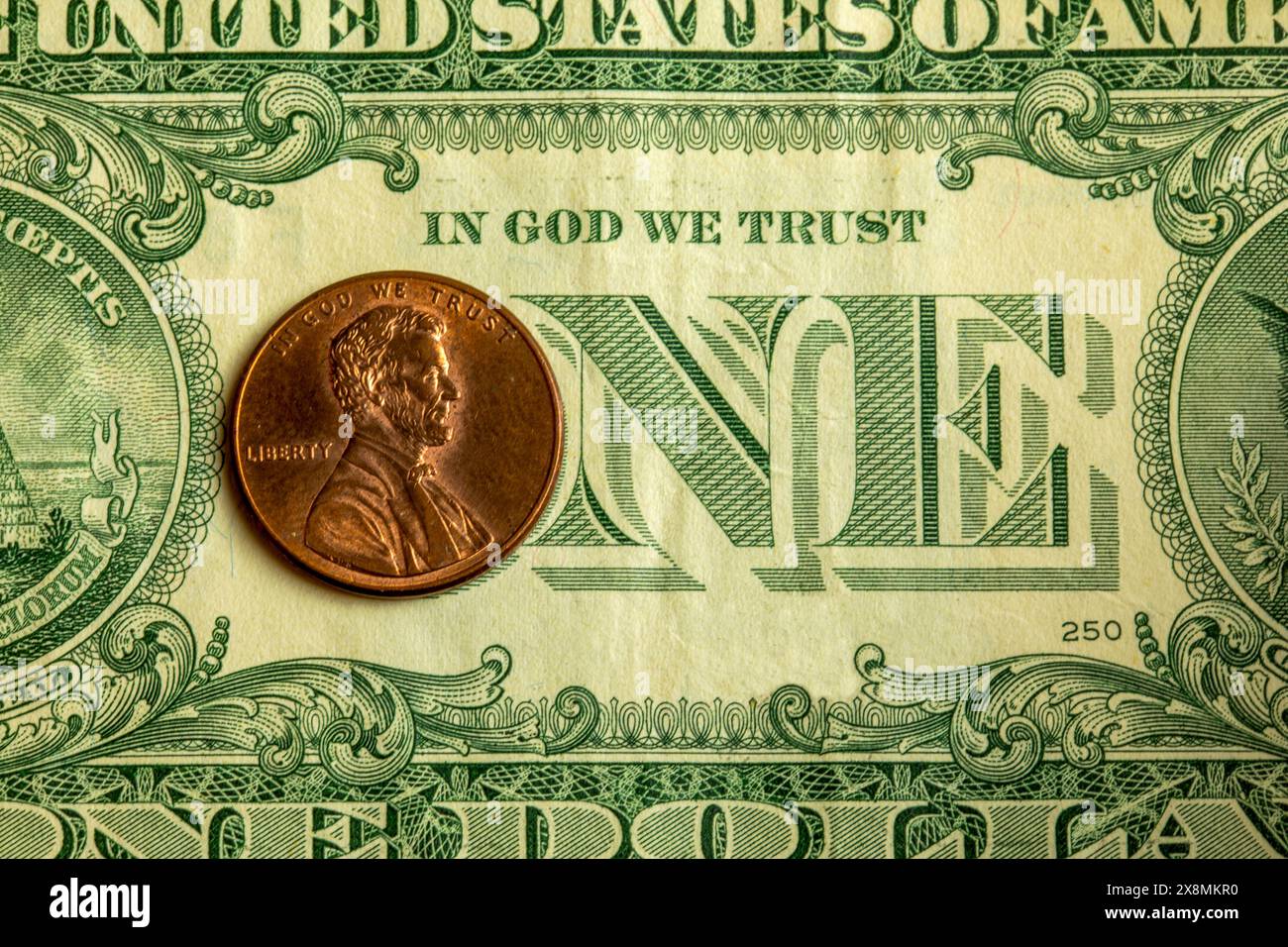 Detail of a one dollar bill with a Abraham Lincoln coin over the "o" in ...
