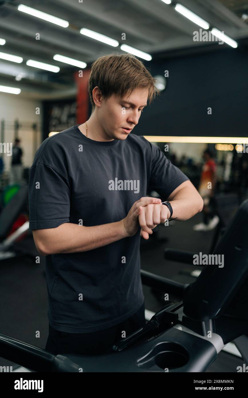 Vertical shot of handsome sportsman check health indicator and heart ...