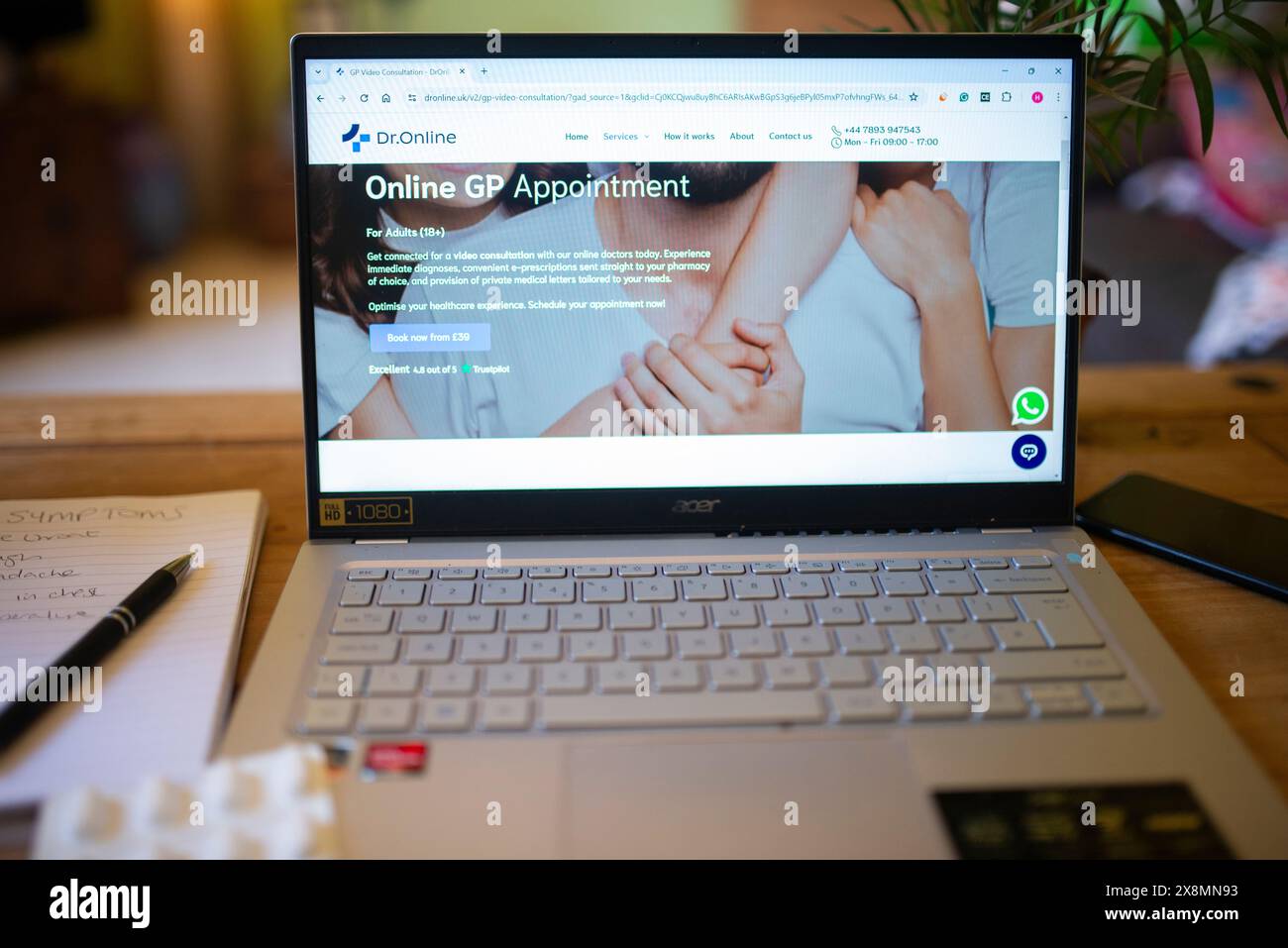 Laptop screen on a living room table showing an online GP appointment ...