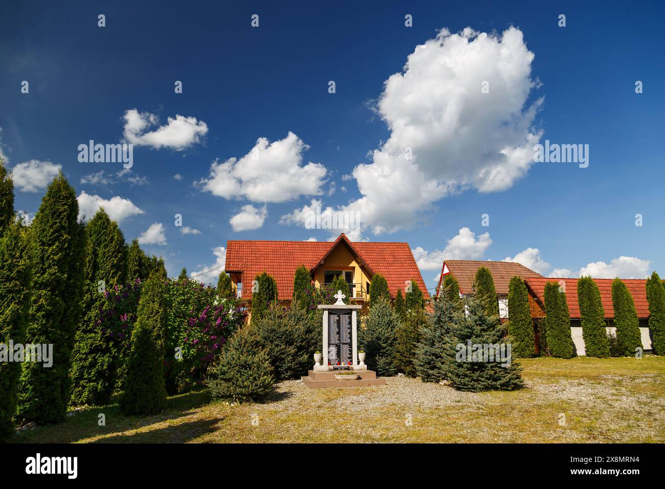 Courtyard of Orthodox church in Avrig town against blue sky with clouds ...
