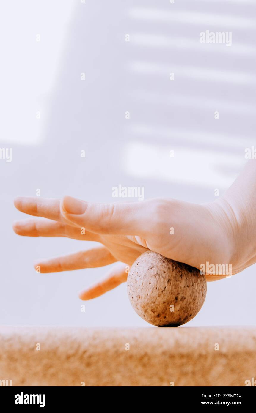 Close up of hand doing palm fascia release exercise with cork ball ...