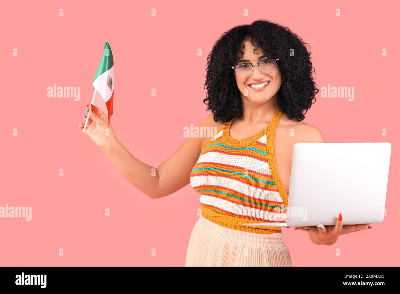 Beautiful woman with Mexican flag and laptop on pink background Stock ...