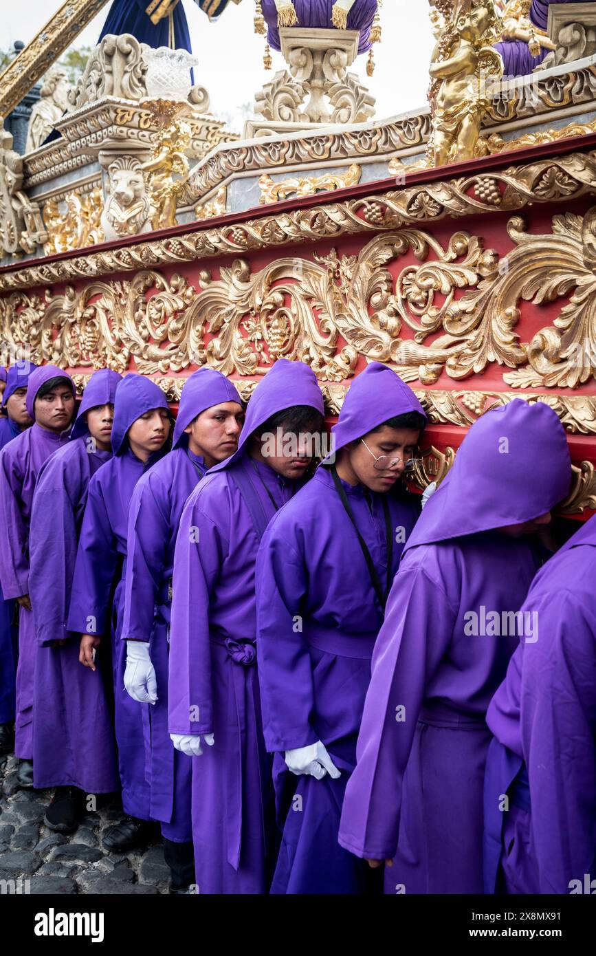 Close-up of young men and boys dressed in purple monks clothes caring ...