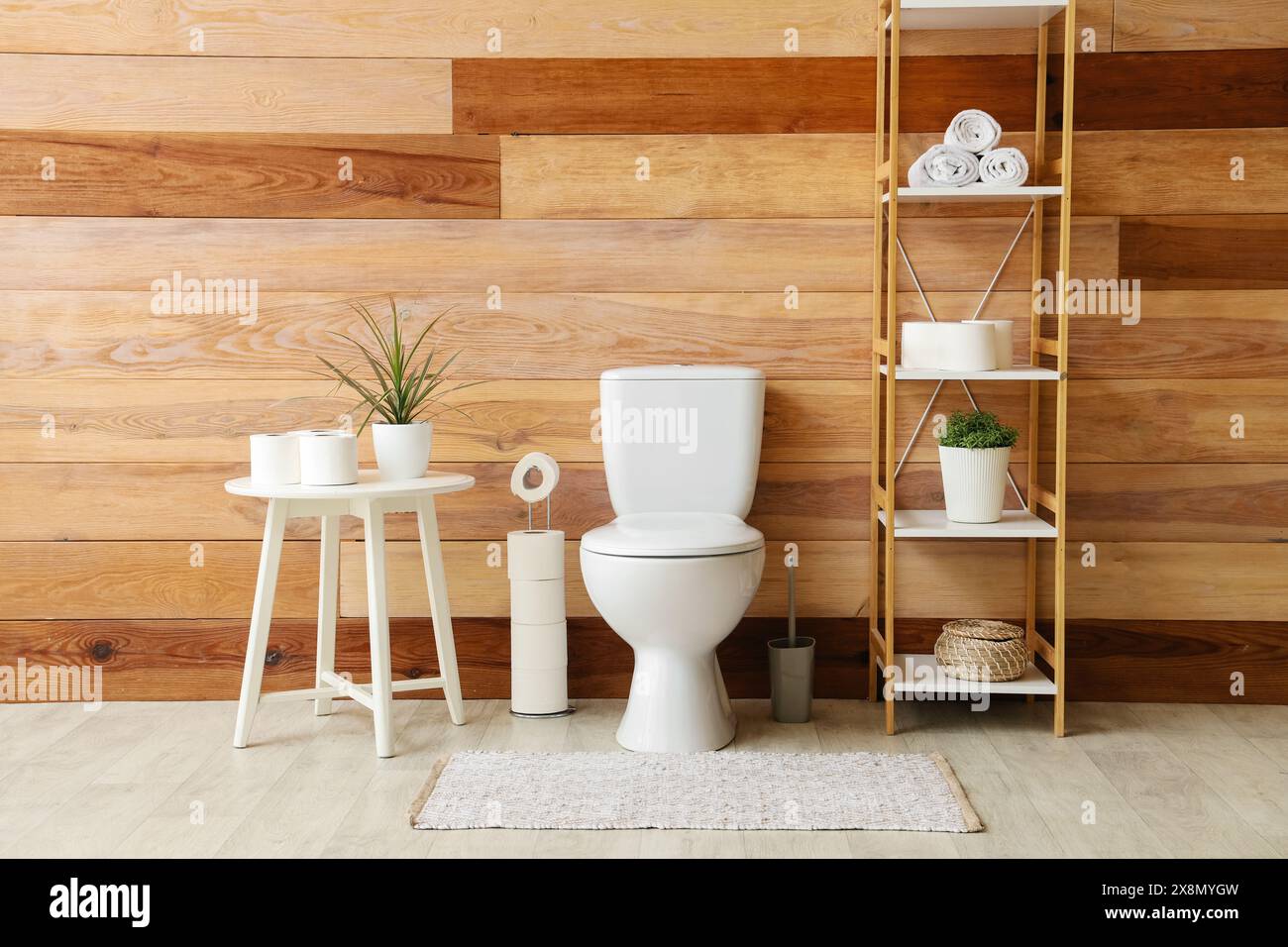 Interior of restroom with toilet bowl, coffee table and shelving unit ...